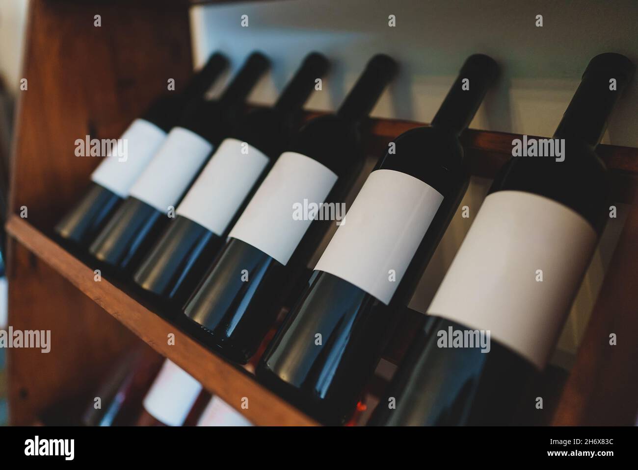 Red wine bottles stacked on wooden rack Stock Photo - Alamy