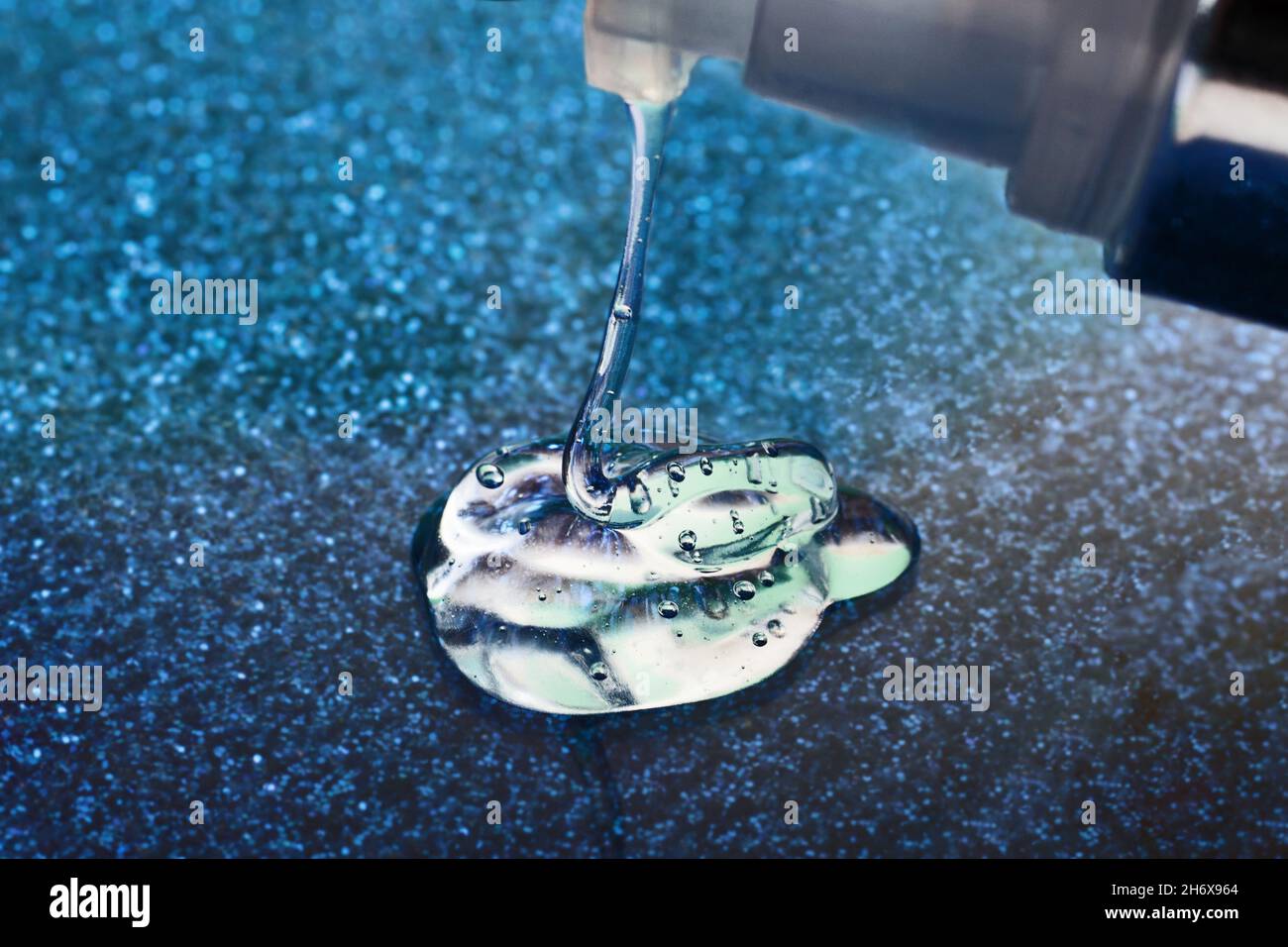 Closeup photography of the dripping liquid cosmetic gel on the blue ...