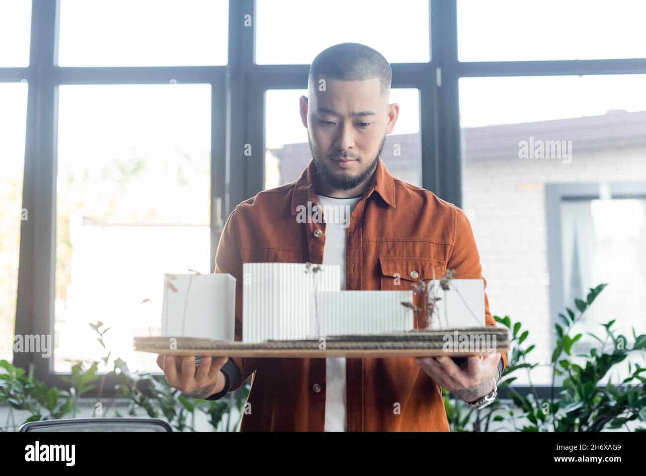 asian architect holding construction project with house models in ...