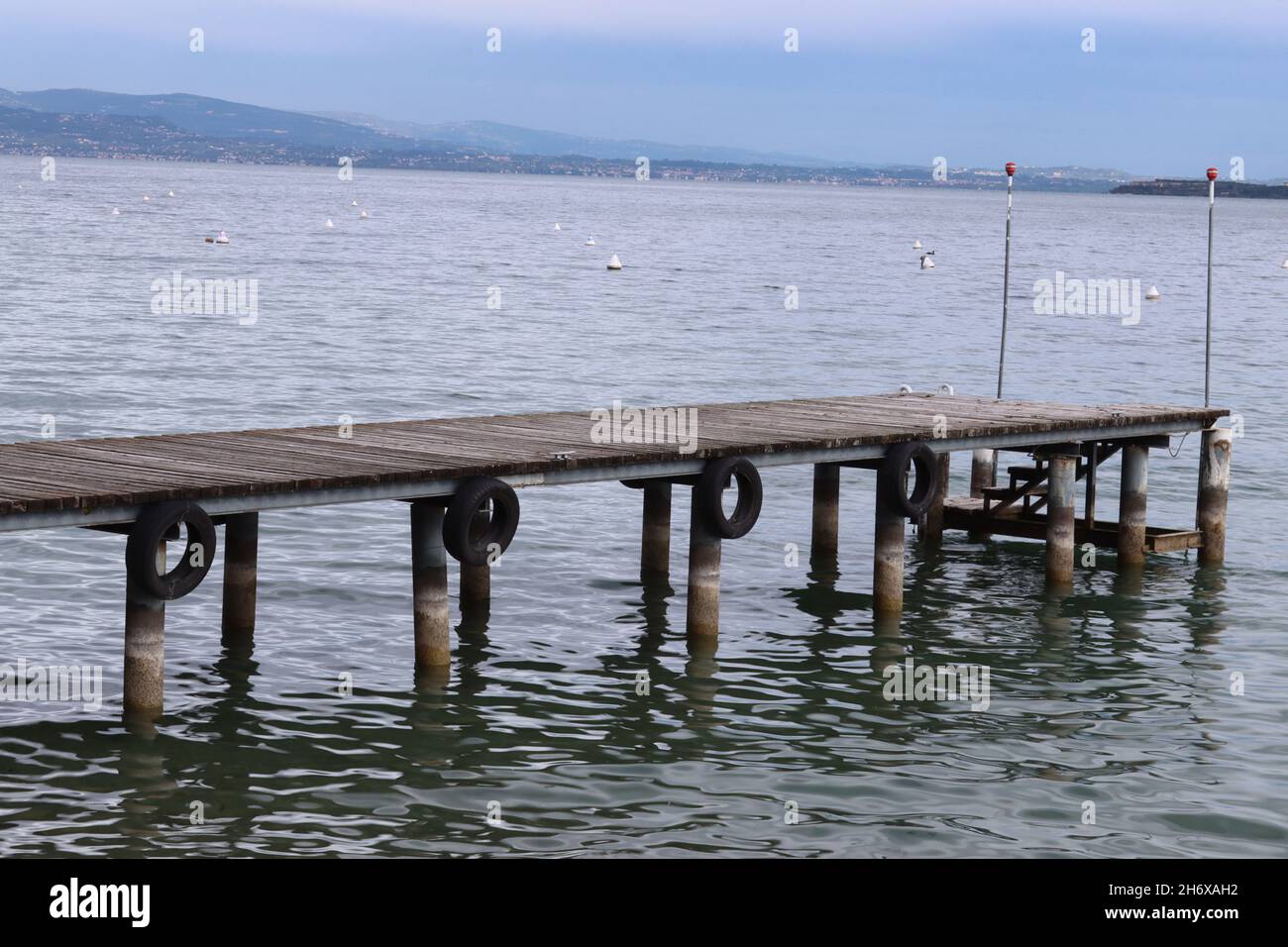 Old empty wooden deck over the lake under a blue cloudy sky during the ...
