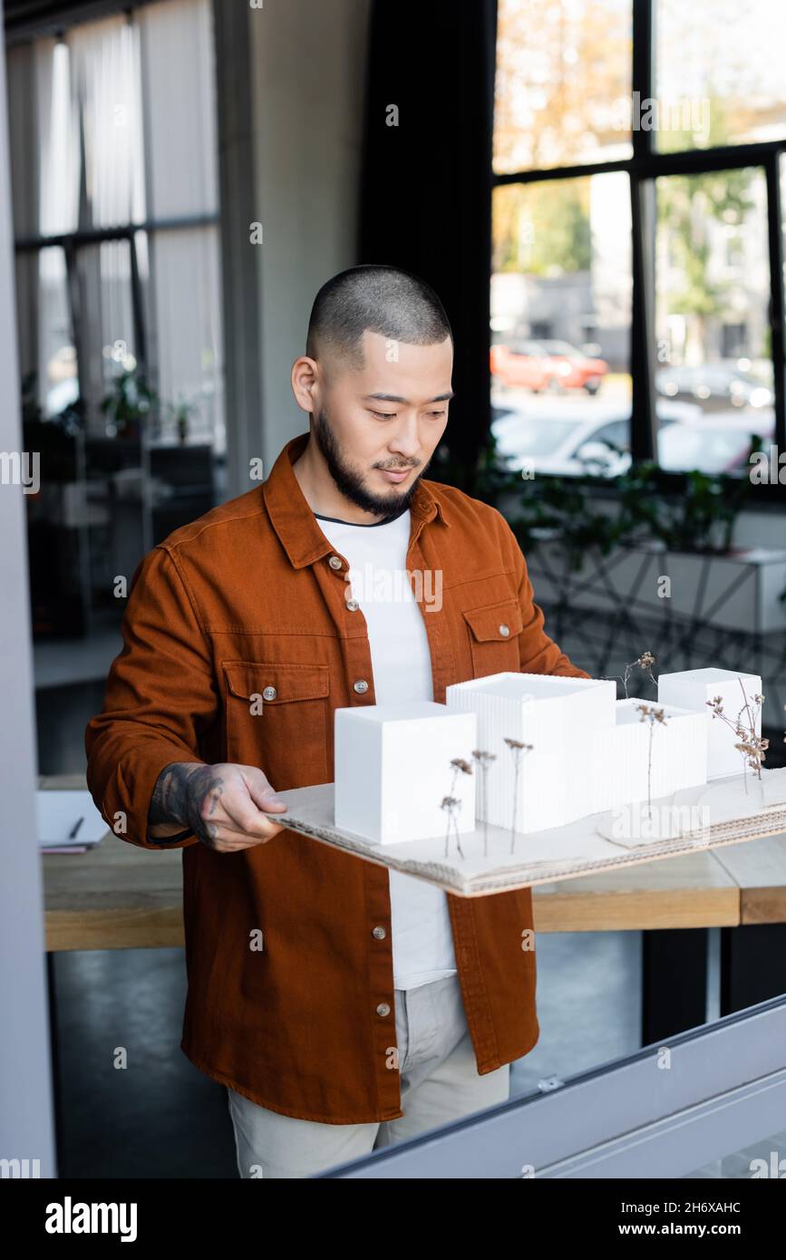 asian architect holding house models while working in architectural ...