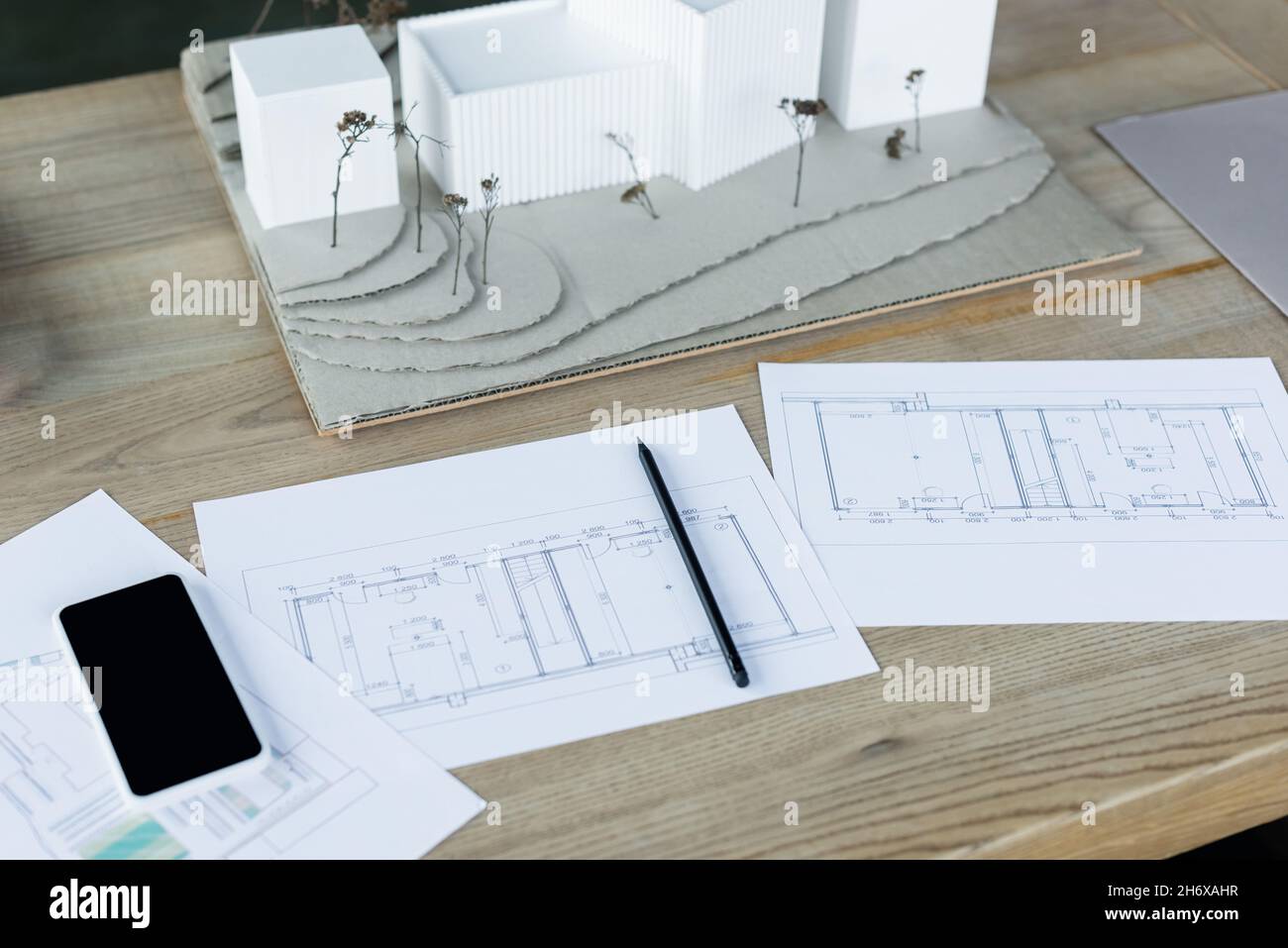 high angle view of architectural plans, house models and mobile phone ...
