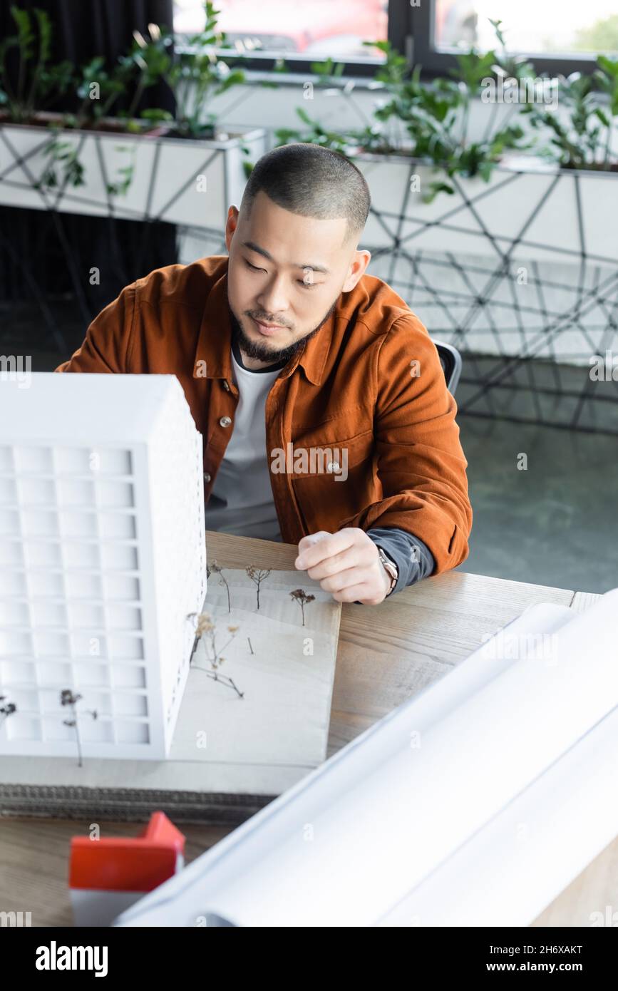 asian engineer working near blurred house model and papers in ...