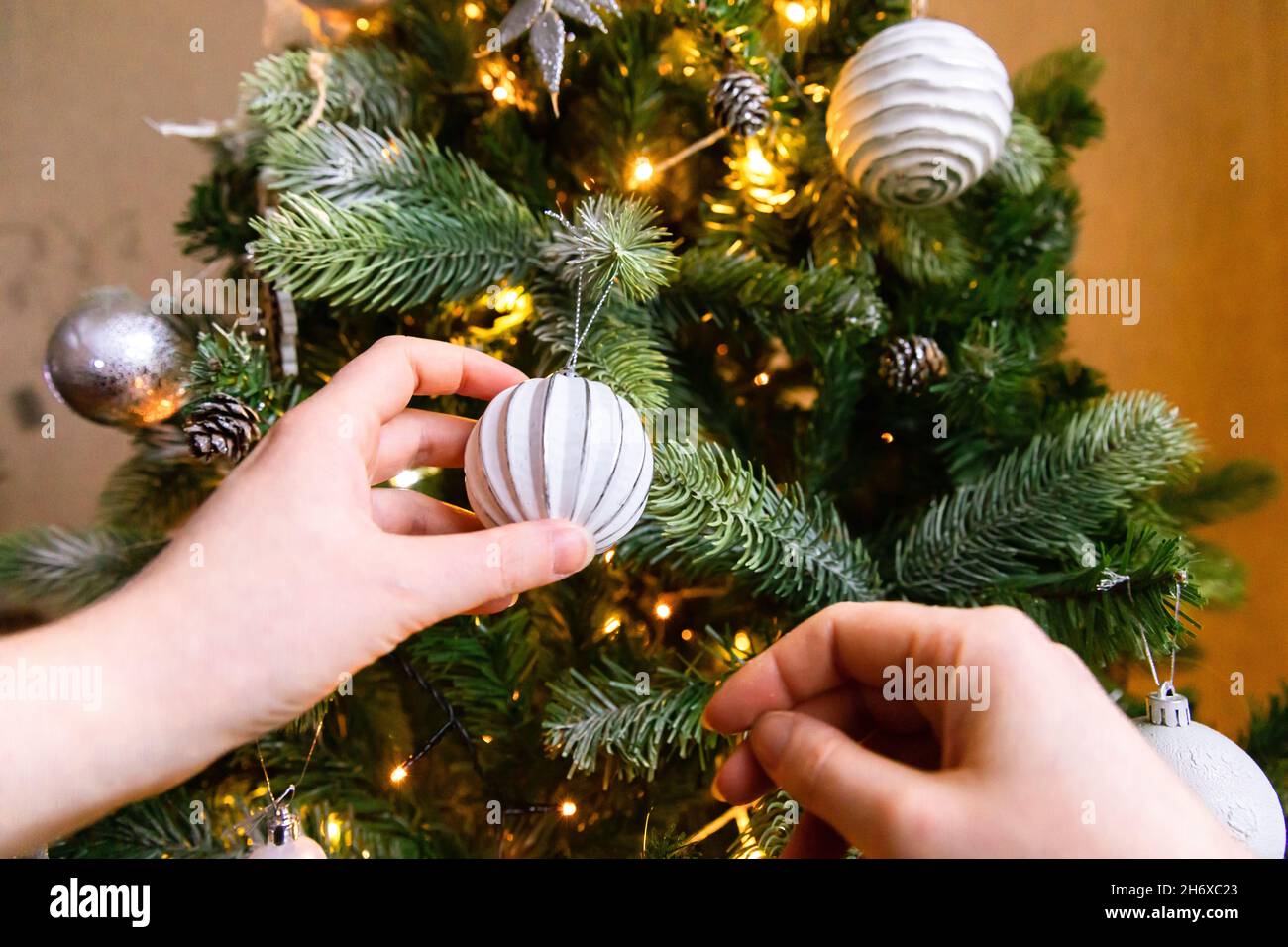 Woman hands decorating Christmas tree. Christmas tree with wite and ...