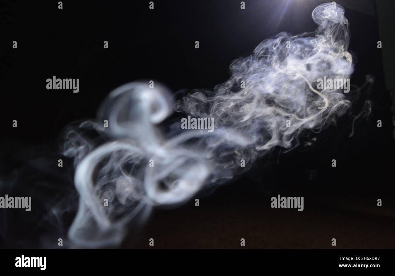 Silky wisps of smoke float off into the night air Stock Photo - Alamy