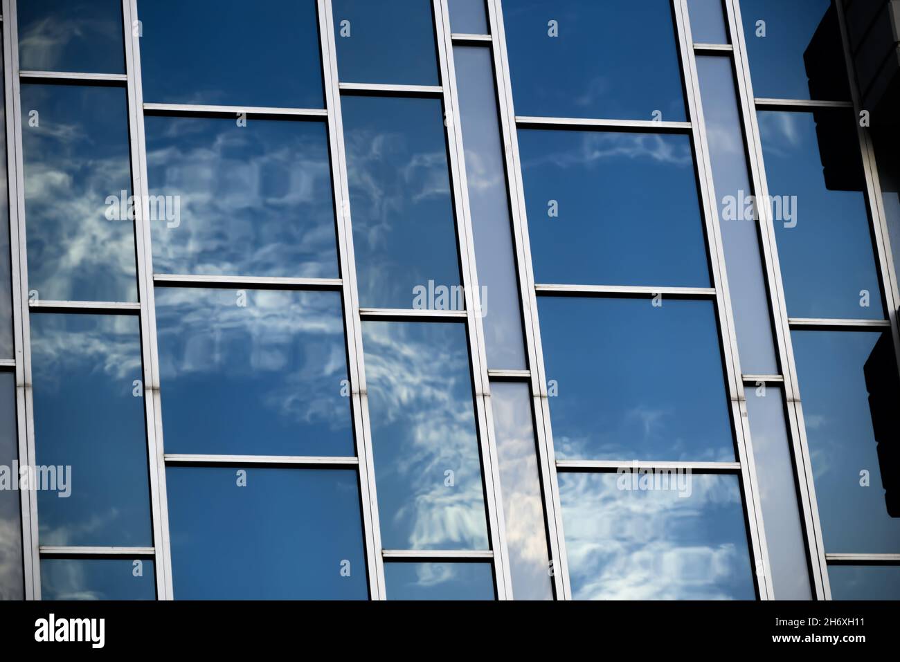 blue sky and clouds reflected from abstract glass windows in ...