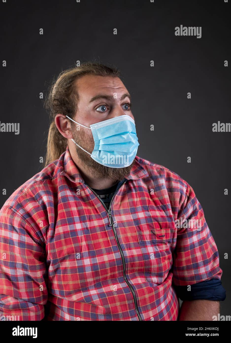 Portrait of afraid man wearing facial mask as virus protection concept ...