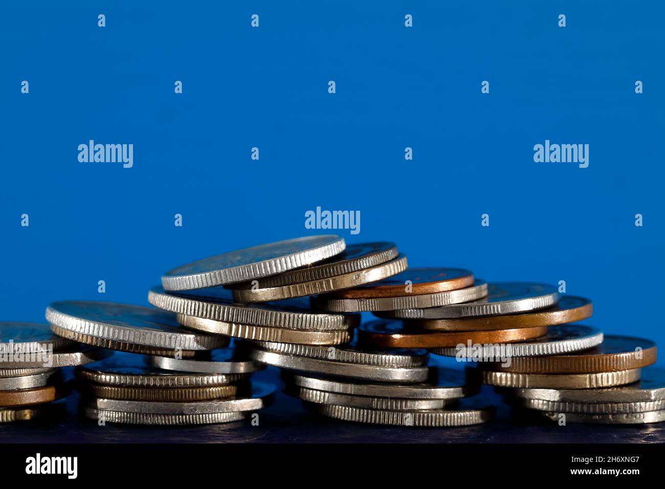 Various coins shown on blue background. The surface on which these ...