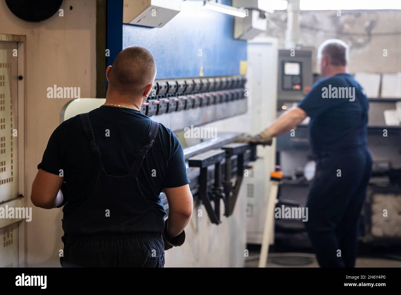 Workers work on sheet metal bending machines Stock Photo - Alamy