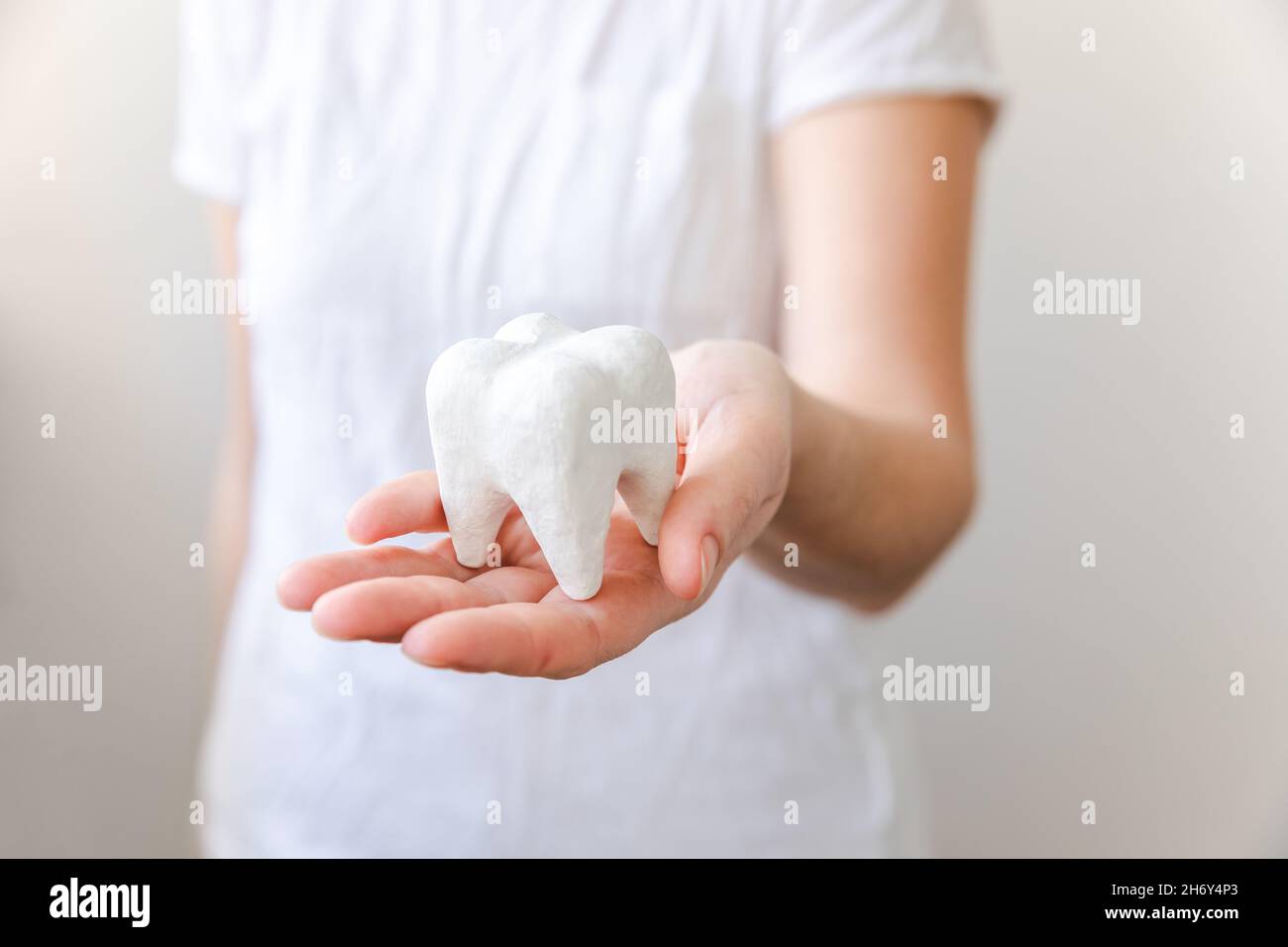 Health dental care concept. Woman hand holding white healthy tooth ...