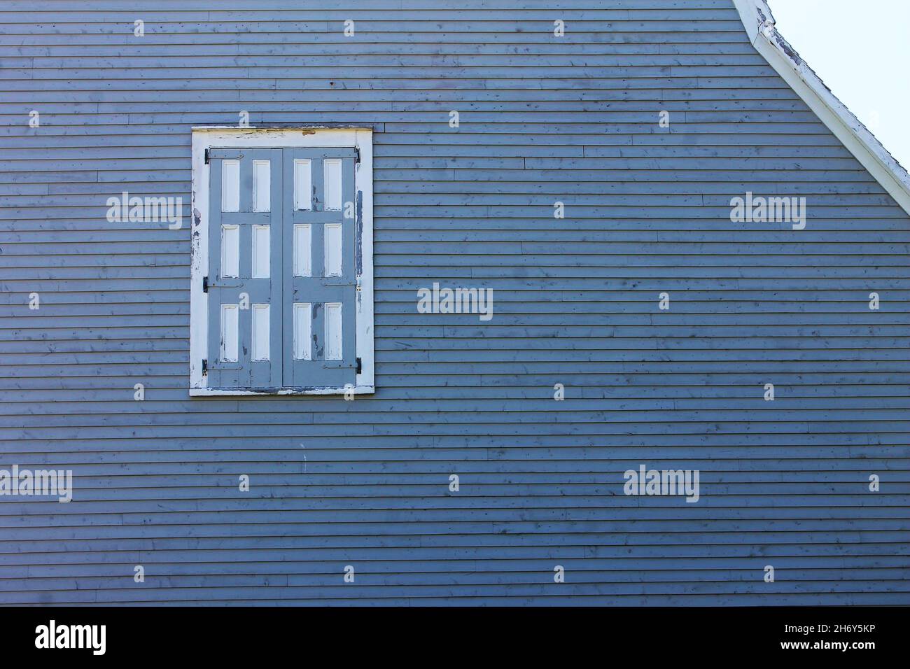 Close-up of an old-fashioned shuttered window with hinged shutters, in ...
