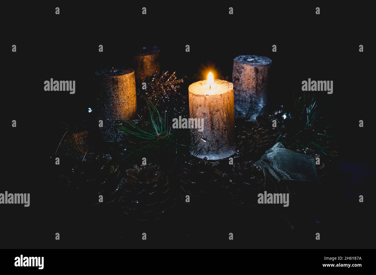 advent concept with first silver burning candle on black background ...