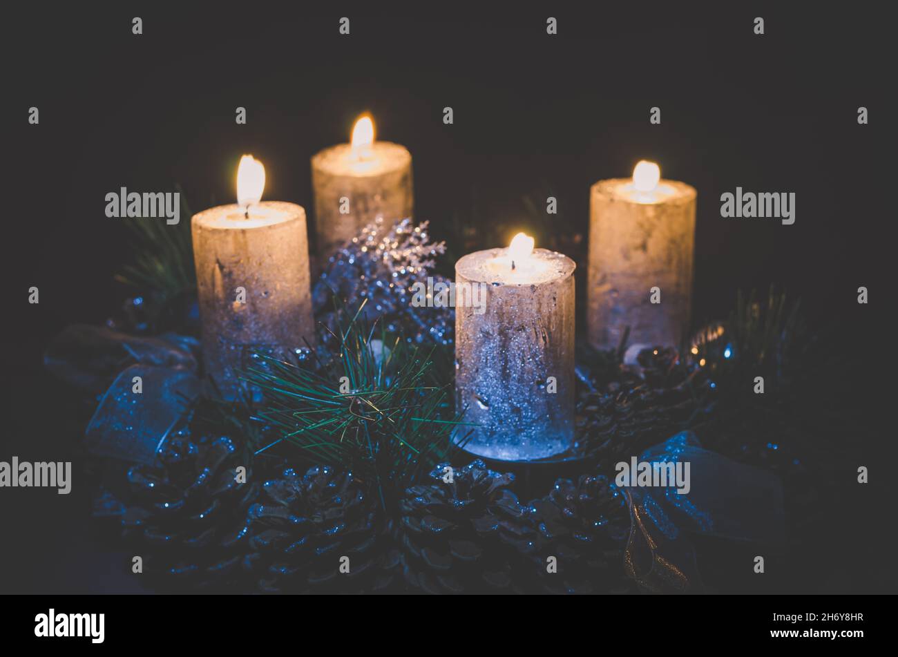 advent concept with four silver burning candle on black background ...