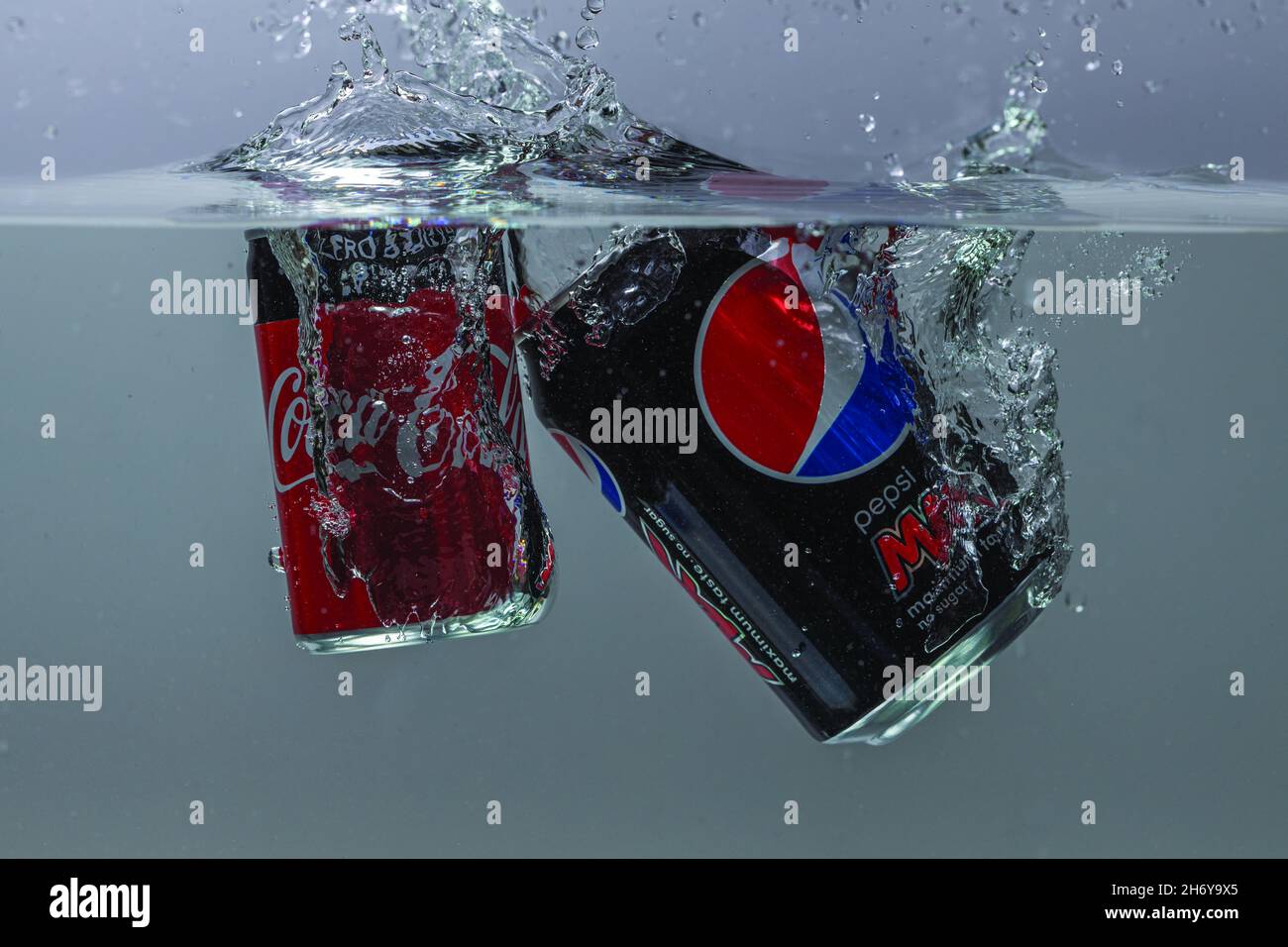 Close up view of can of coca cola, pepsi cola falling into water ...