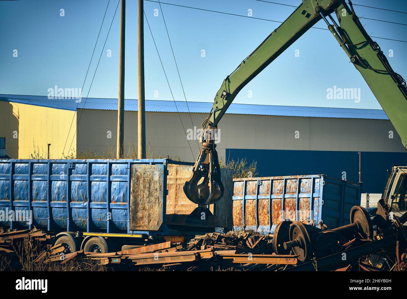 Crane loads dipper truck with scrap metal Stock Photo - Alamy