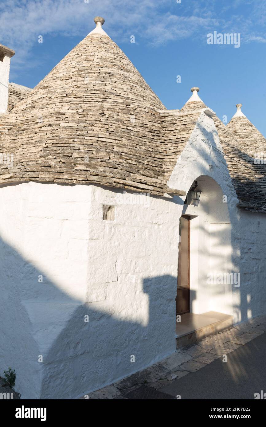 Traditional Trulli buildings lined with colorful flowers in Alberobello ...