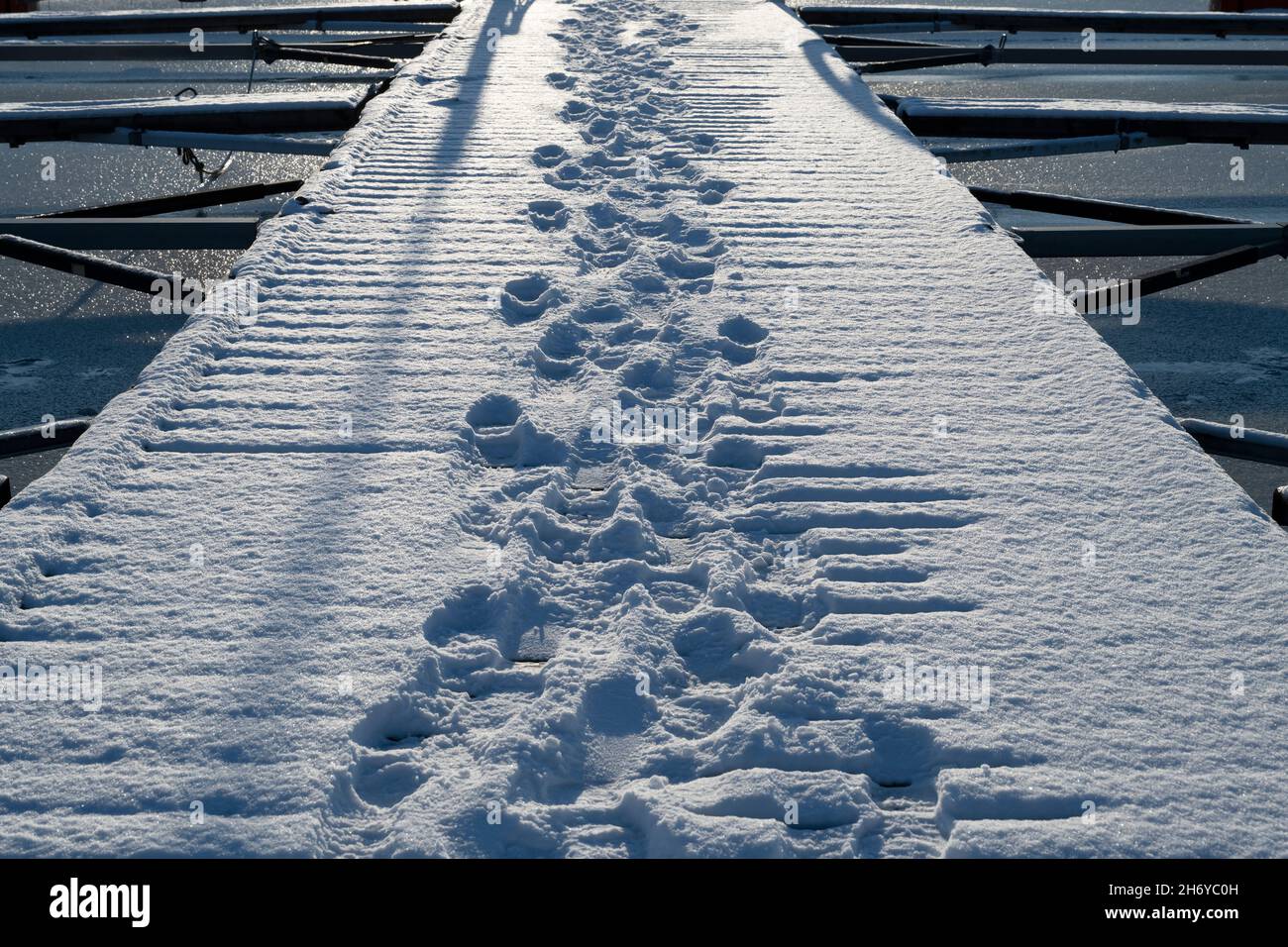 Snow covered jetty with footsteps Stock Photo - Alamy