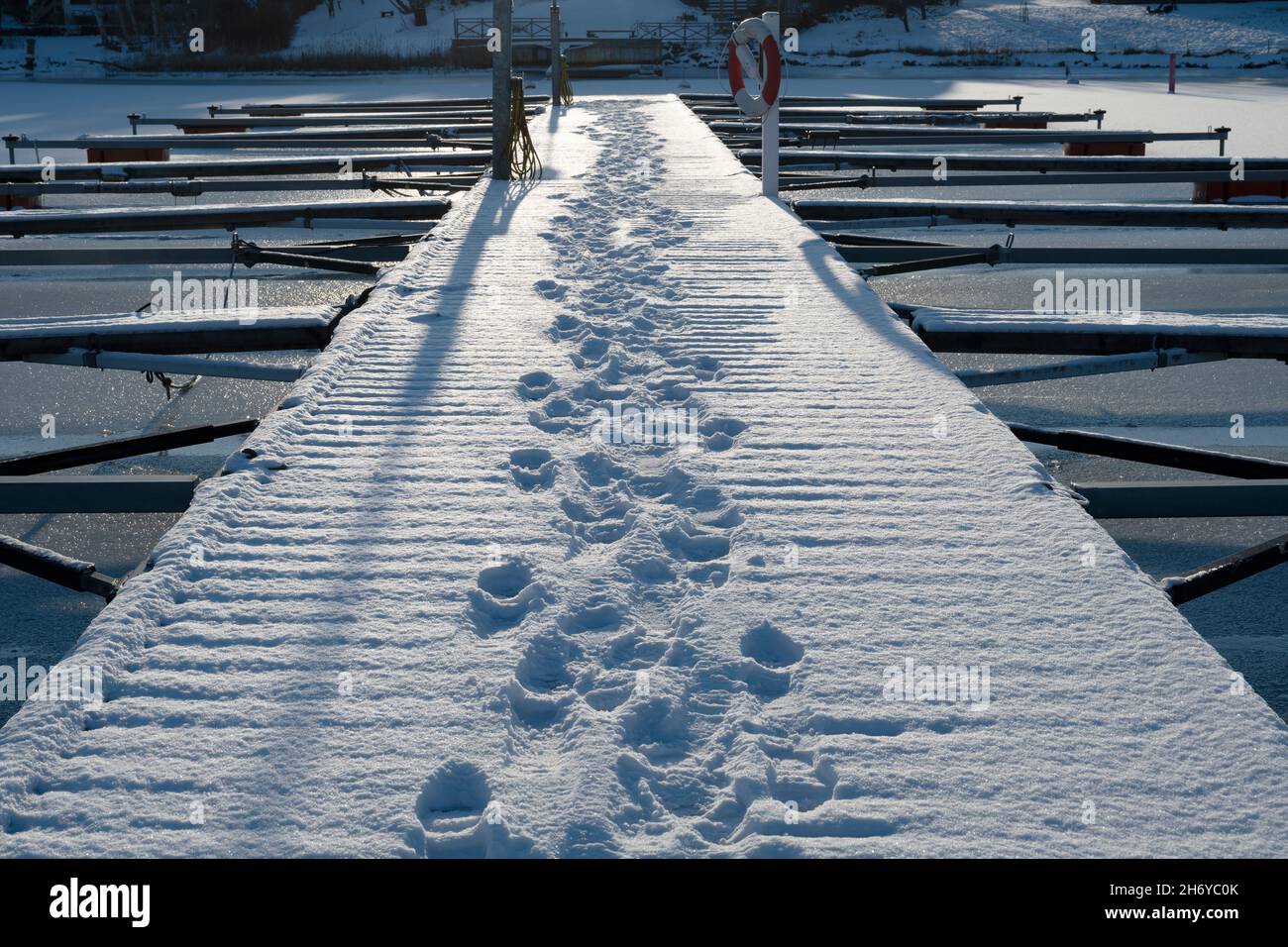 Snow covered jetty with footsteps Stock Photo - Alamy