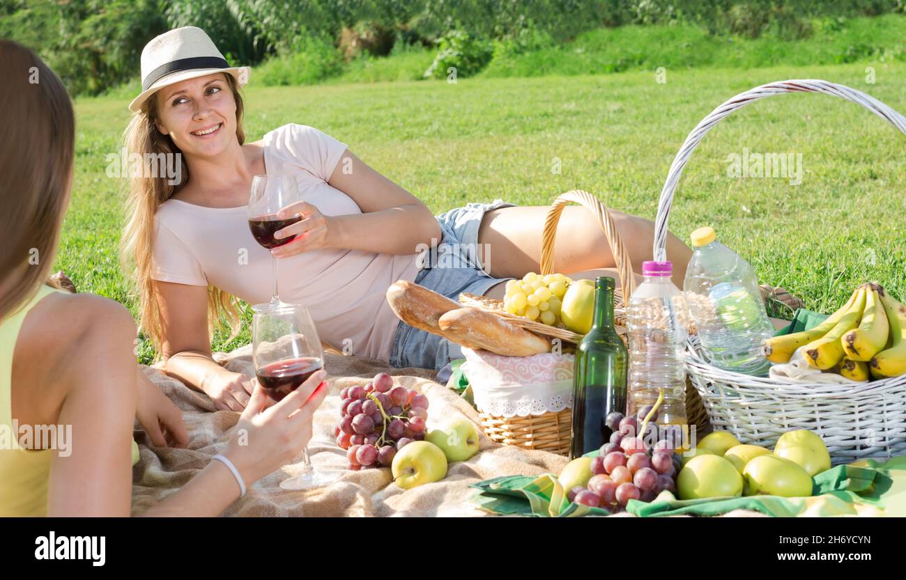 Two young women enjoying wine and conversation on picnic outdoors Stock ...