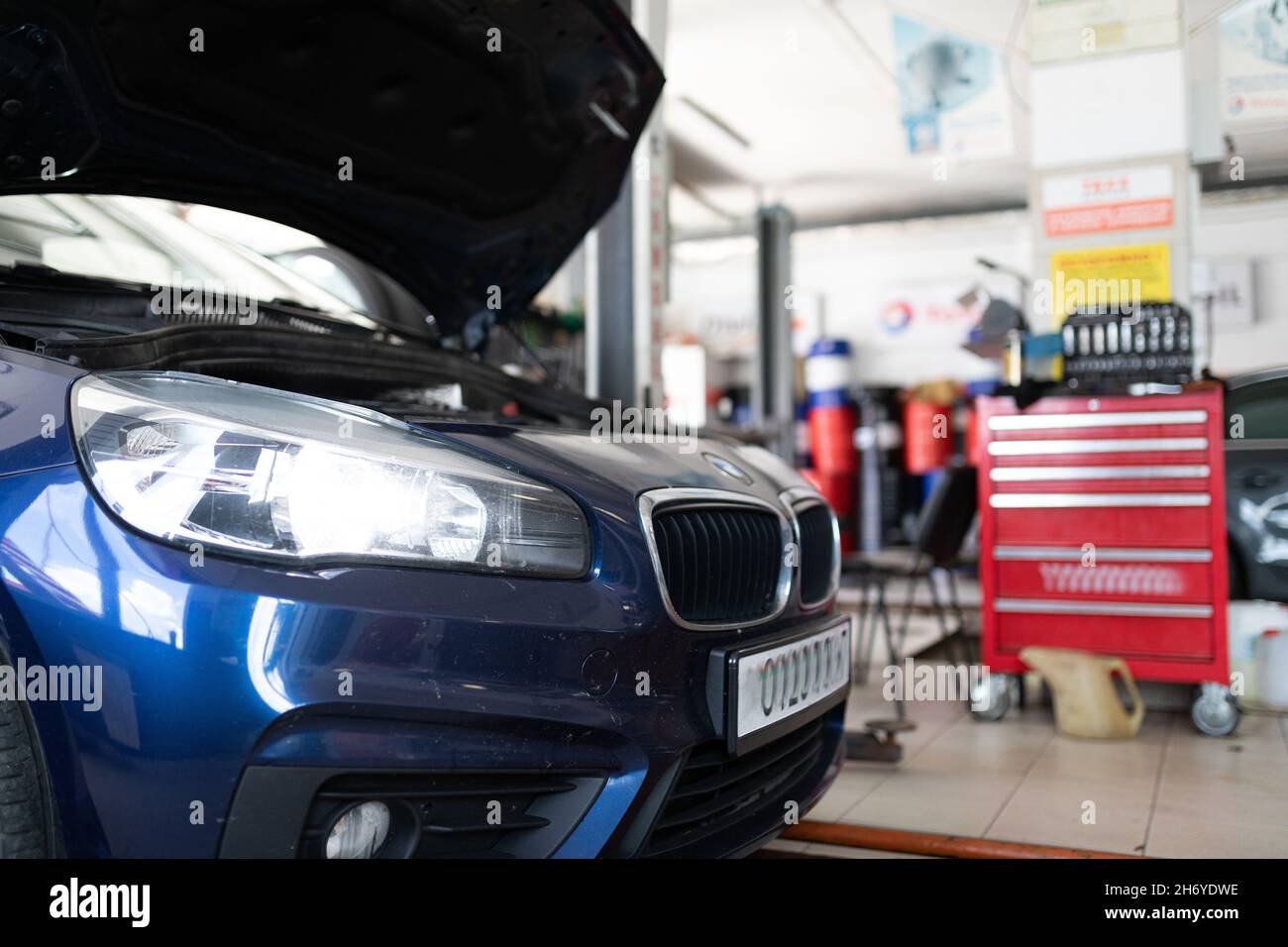 Close-up photo of a blue passenger car at a service station under ...