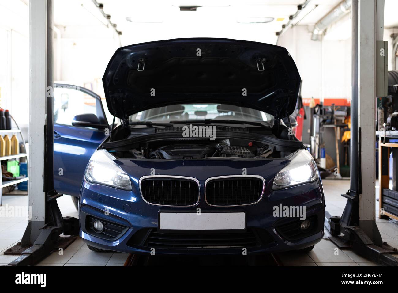 Photo of a blue passenger car at the service station being repaired ...