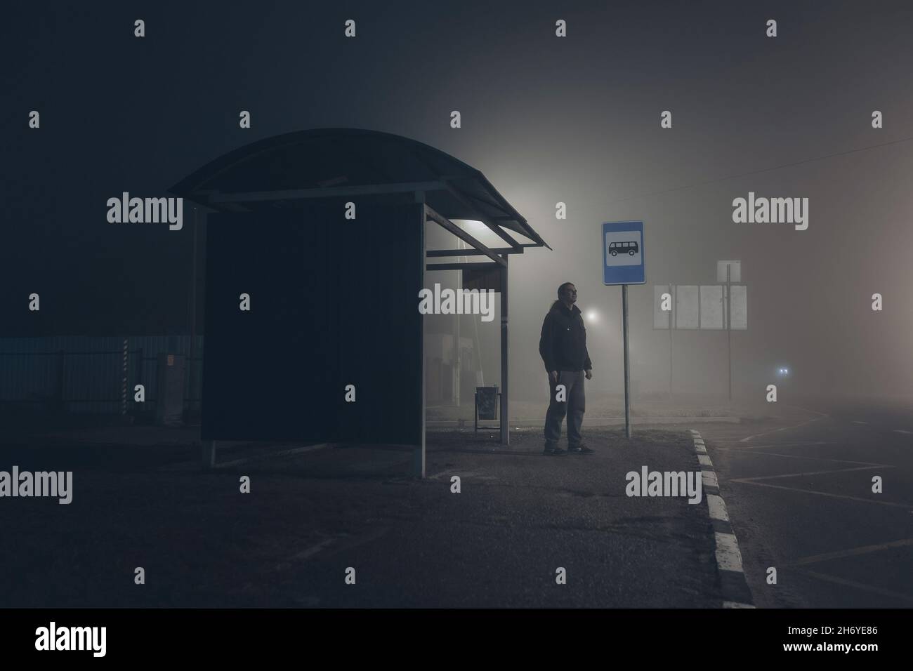 Alone sad man waiting for bus at bus stop Stock Photo - Alamy