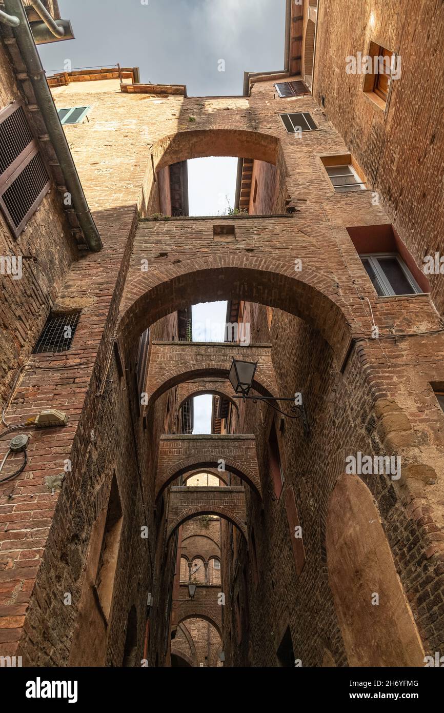 Multiple Arches, narrow streets, brickstone walls in Via della Galluzza ...