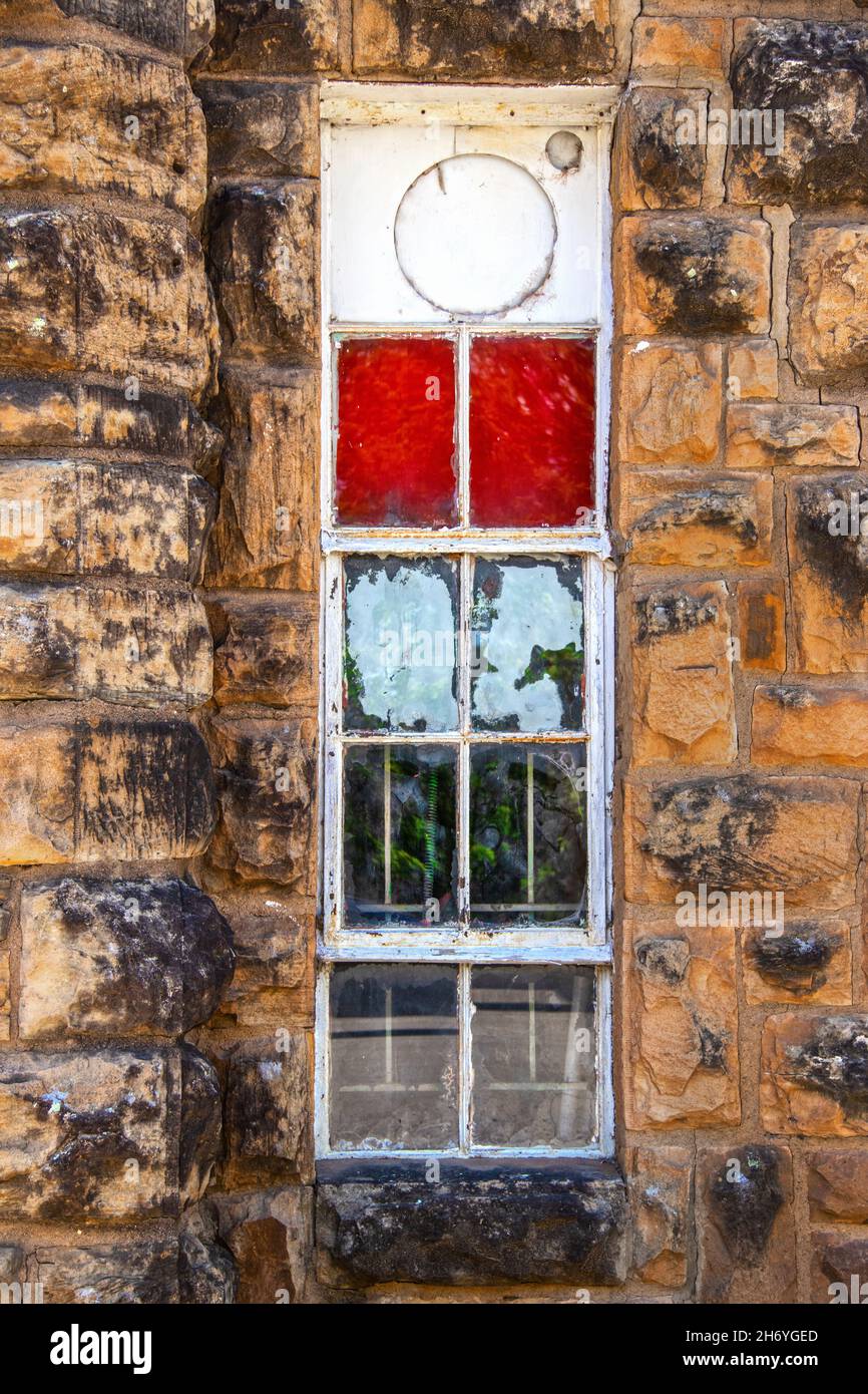 Vertical old grungy window in rustic rock building with peeling painted ...