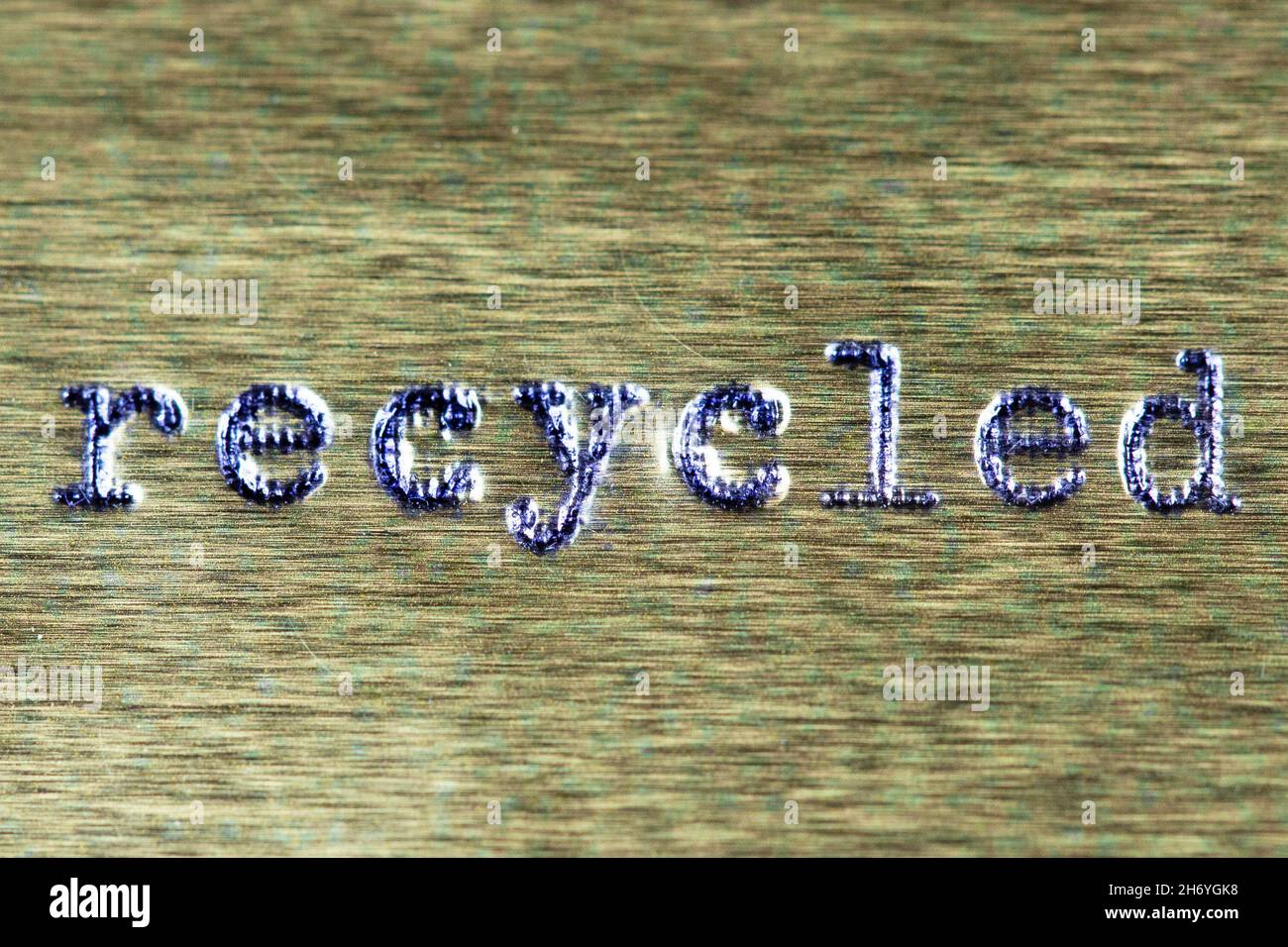 The word "recycled" in old manual typewriter typeface on metallic ...