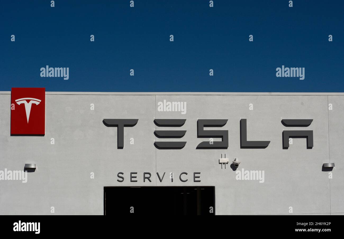 Tesla logo and signage on the exterior of a Tesla dealership and ...