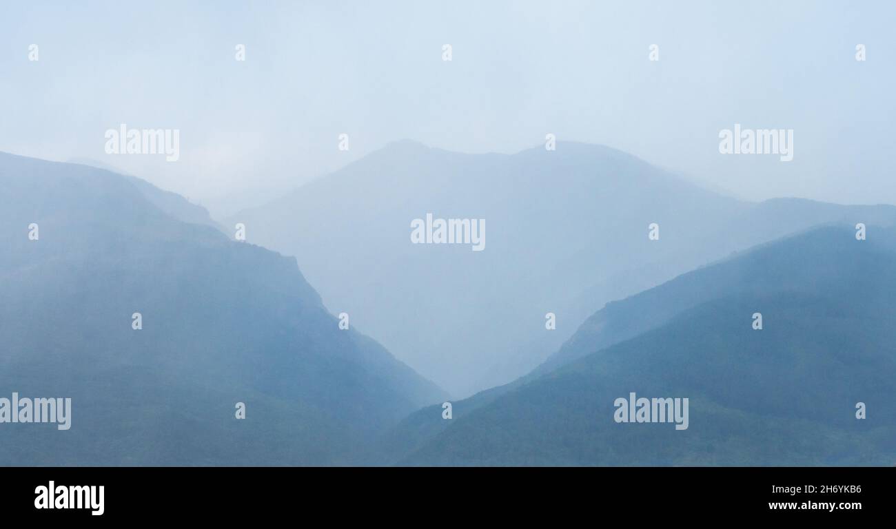 fog over a mountain pass and a hidden mystical valley with transparent ...