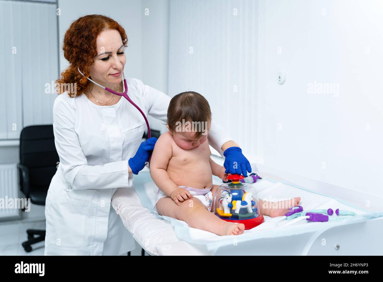Little girl at doctor for checkup. Doctor pediatrician and baby patient ...