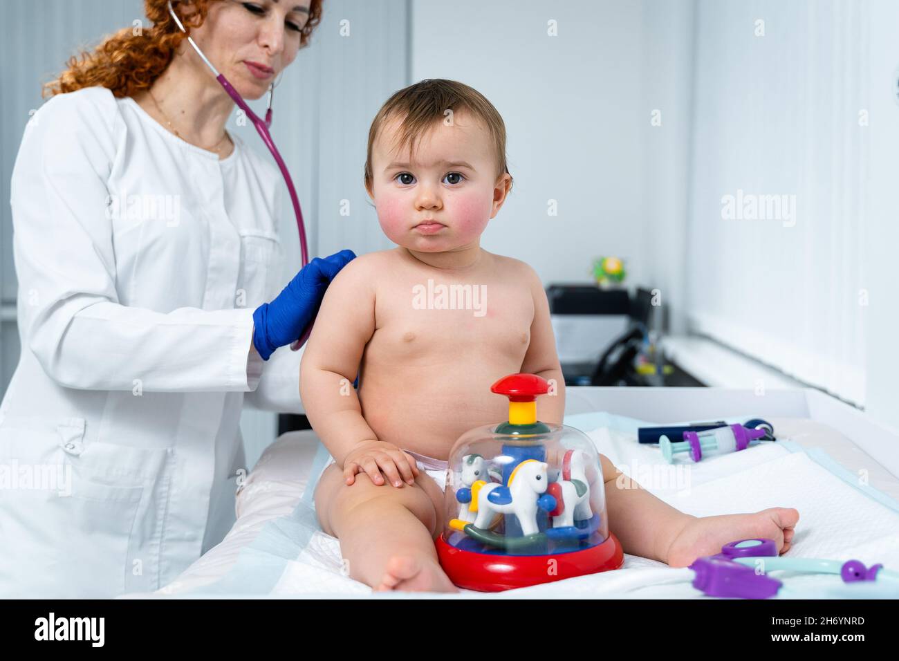 Little girl at doctor for checkup. Doctor pediatrician and baby patient ...