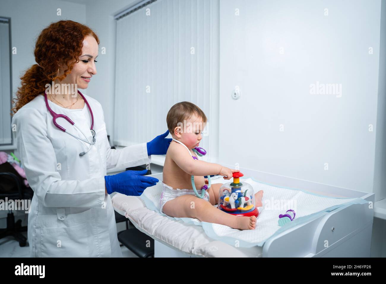 Pediatrician providing healthcare for her baby patient in the office of ...