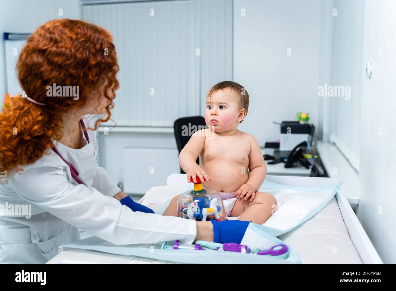 Pediatrician providing healthcare for her baby patient in the office of ...