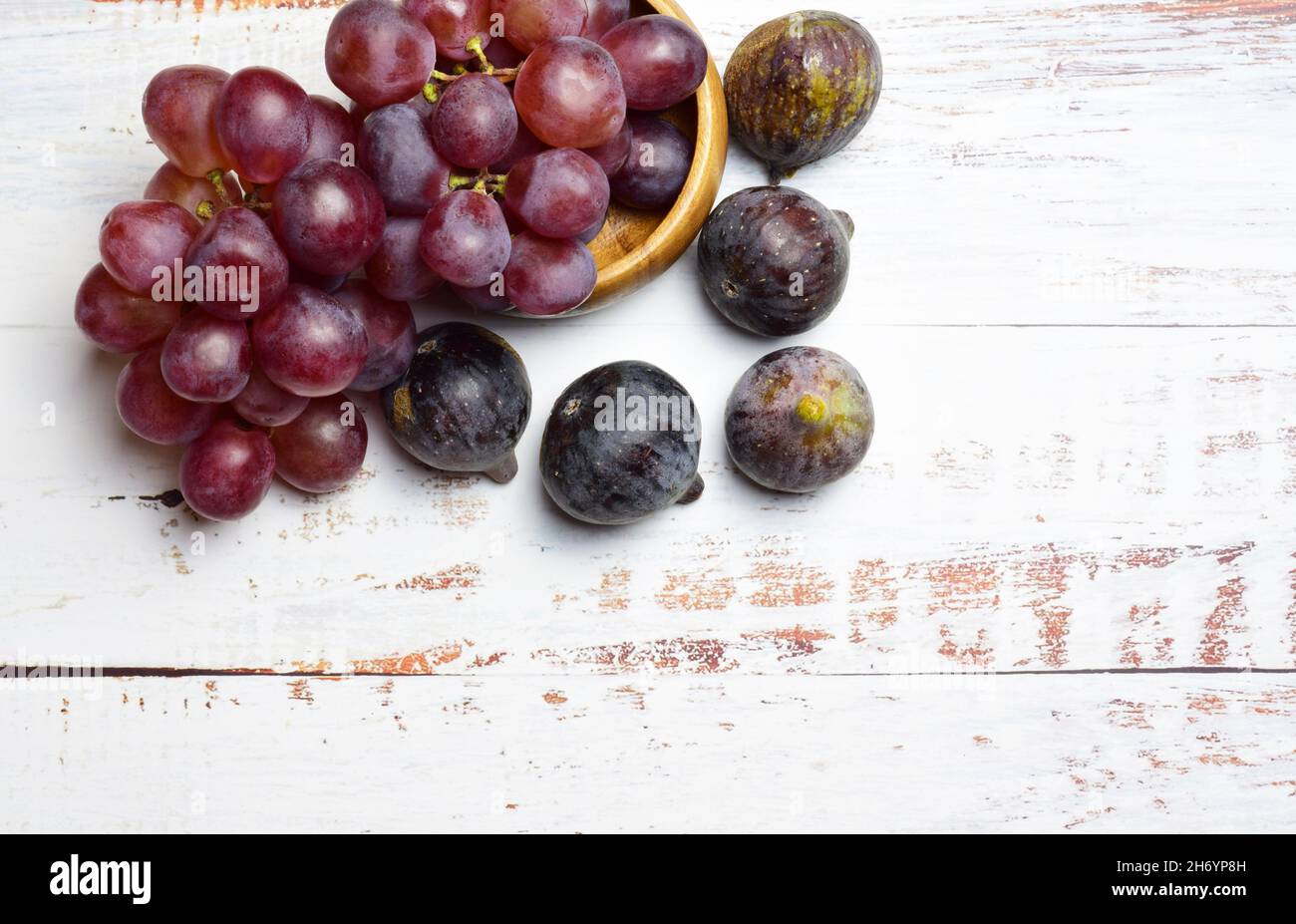 Top view of ripe purple figs and grapes isolated on white wooden ...