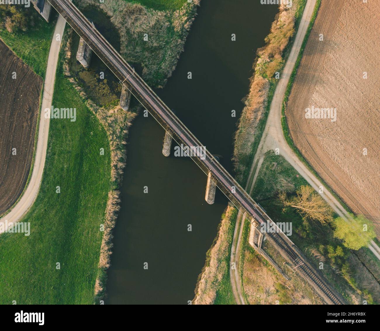 Aerial shot of a thin bridge with an asphalt road that goes over a ...