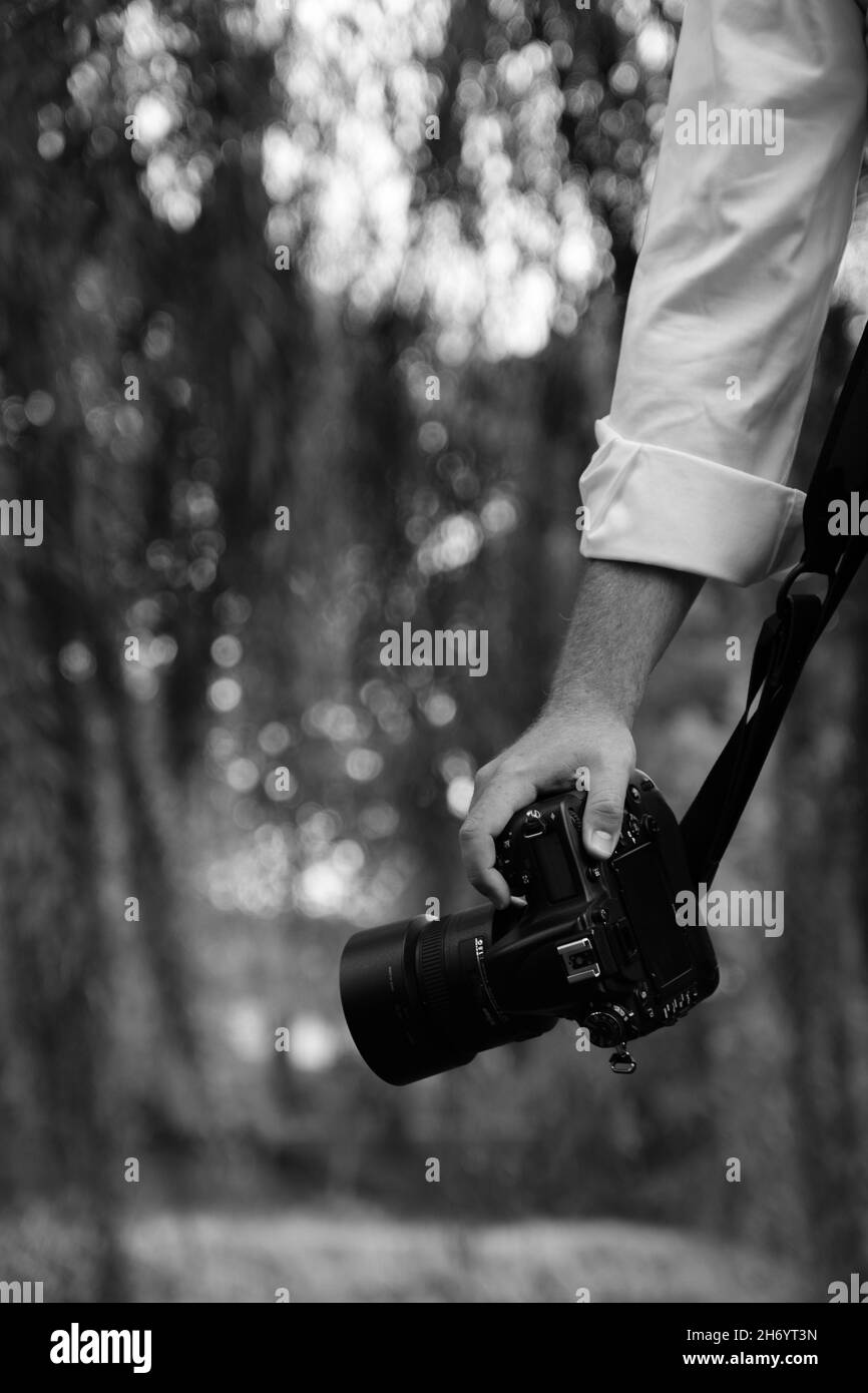 Vertical grayscale shot of the male hand holding a camera Stock Photo ...