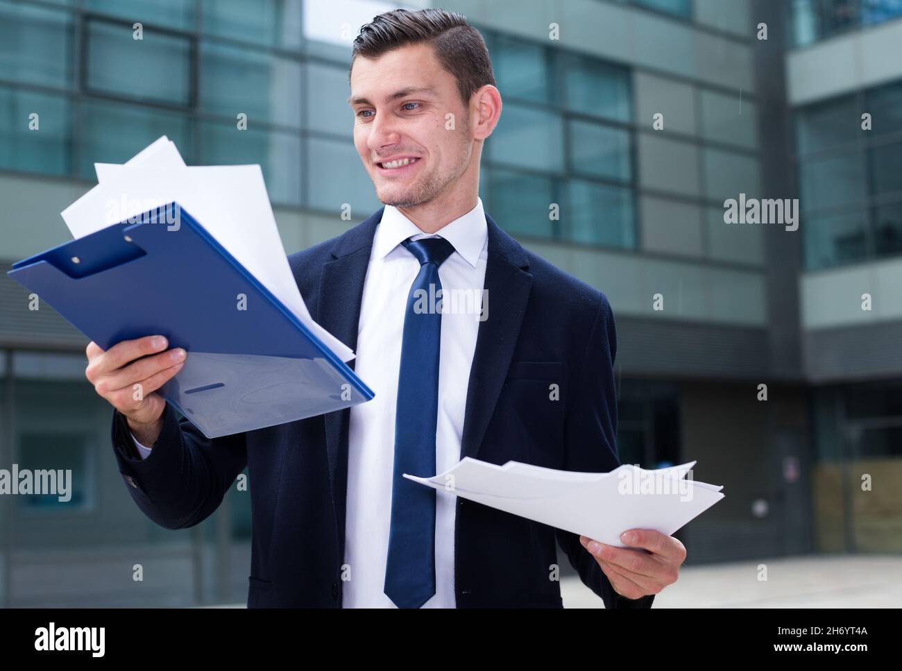 Smiling employee is examining documents before signing Stock Photo - Alamy Smiling employee is examining documents before signing Stock Photo - Alamy