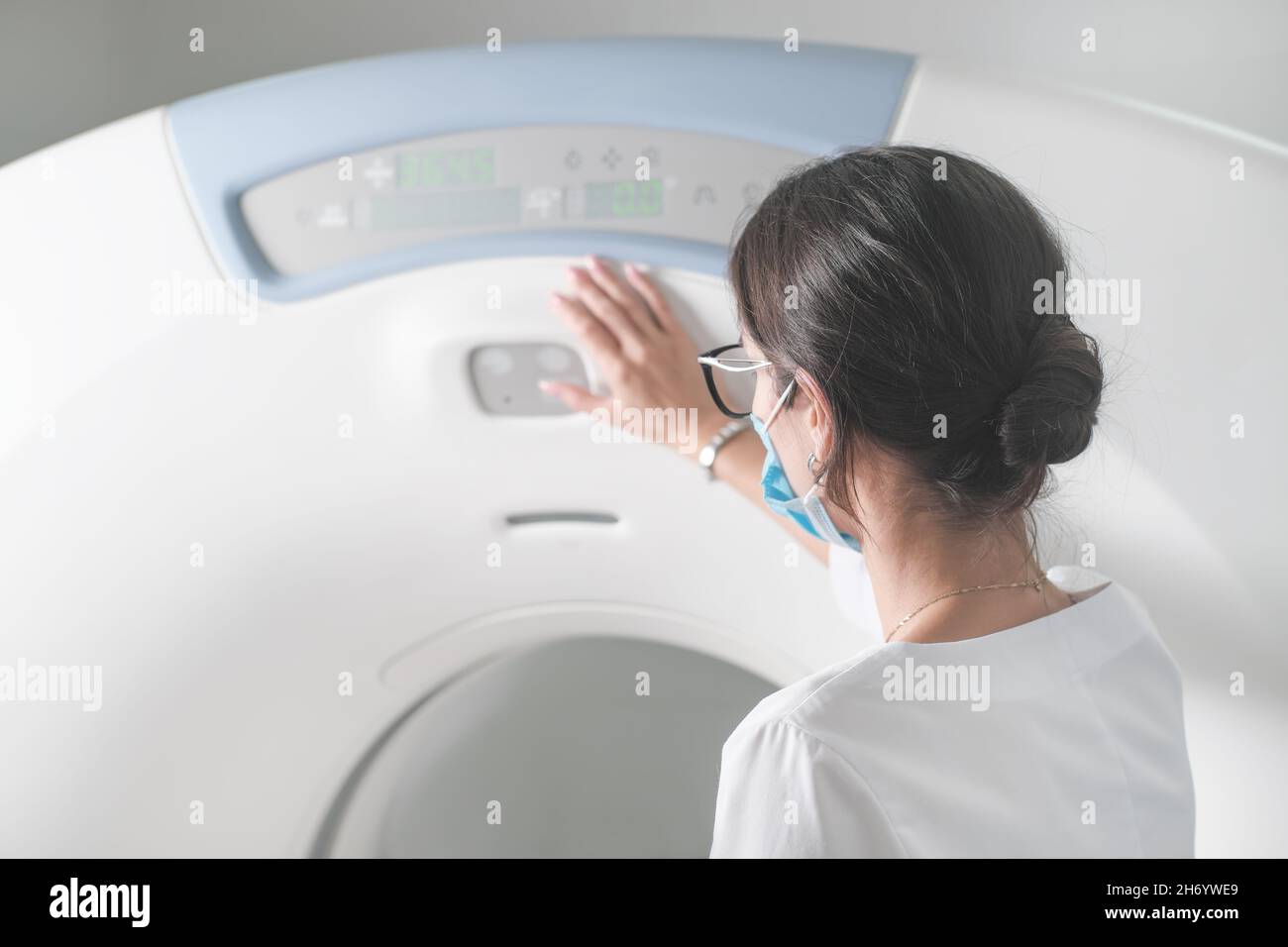 woman radiologist doctor adjusting computer tomography scanner machine ...
