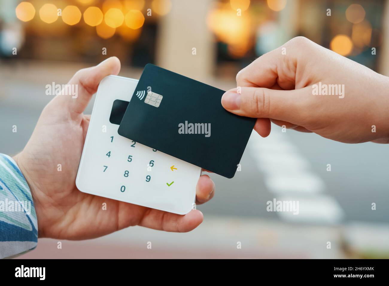 Unrecognizable customer with contactless black credit card paying to ...