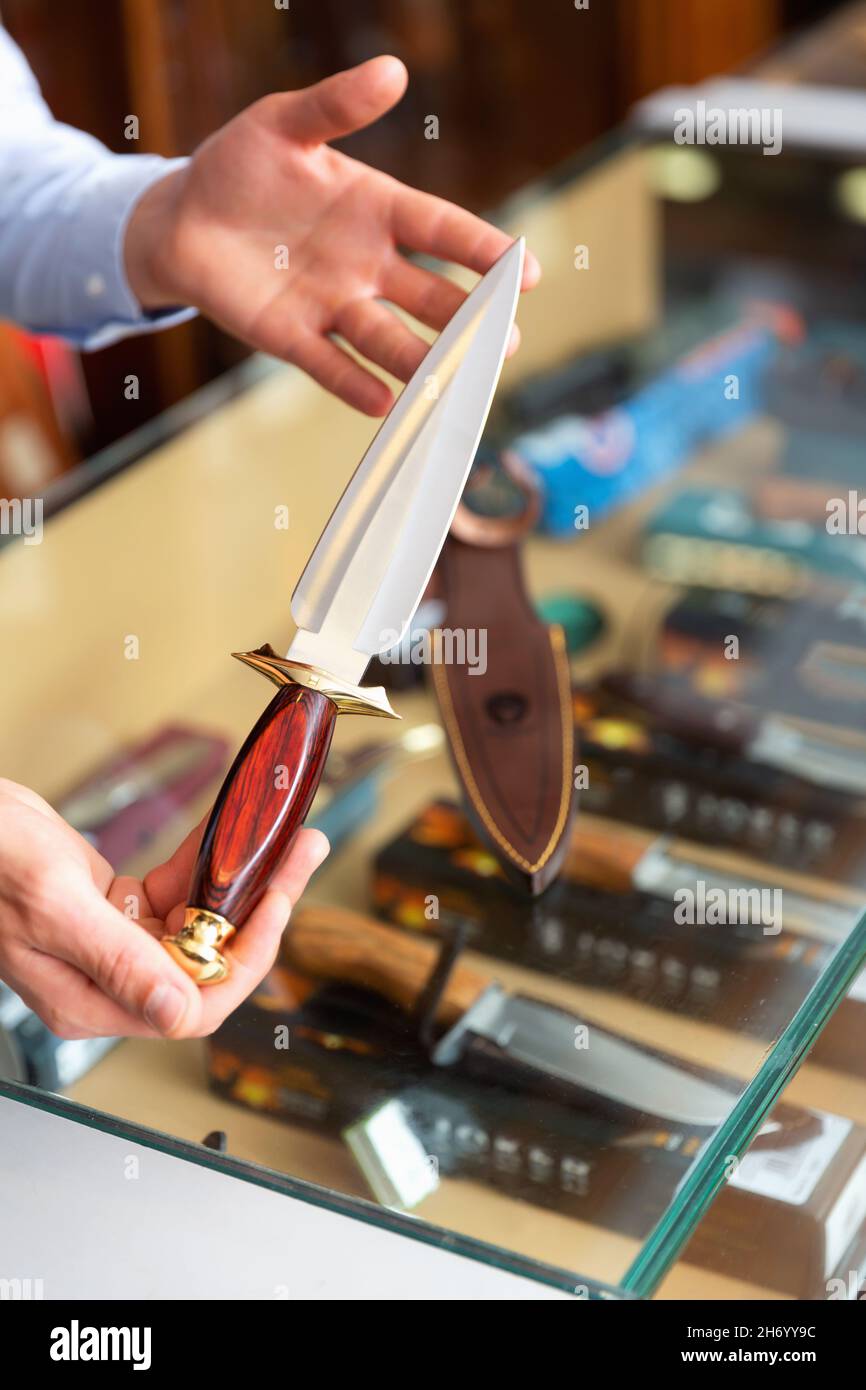Closeup of hunting dagger in hands of gun shop seller Stock Photo - Alamy