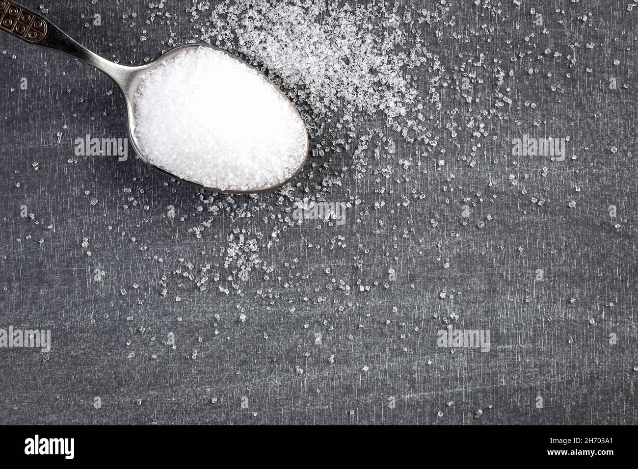 Teaspoon with white sugar. Black chalk board Stock Photo - Alamy