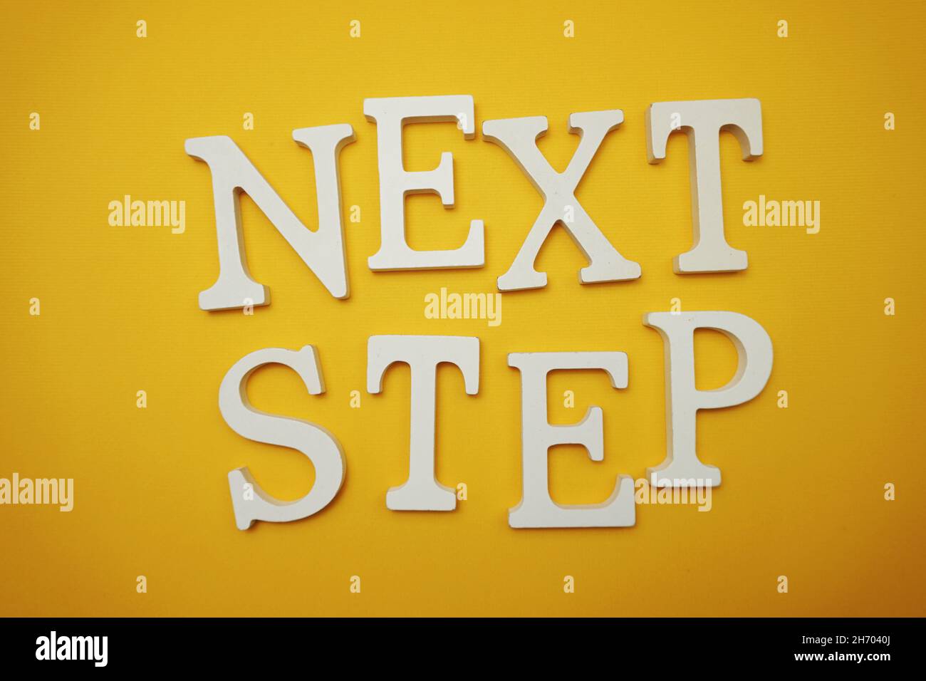 Next Step alphabet letter on yellow background Stock Photo - Alamy