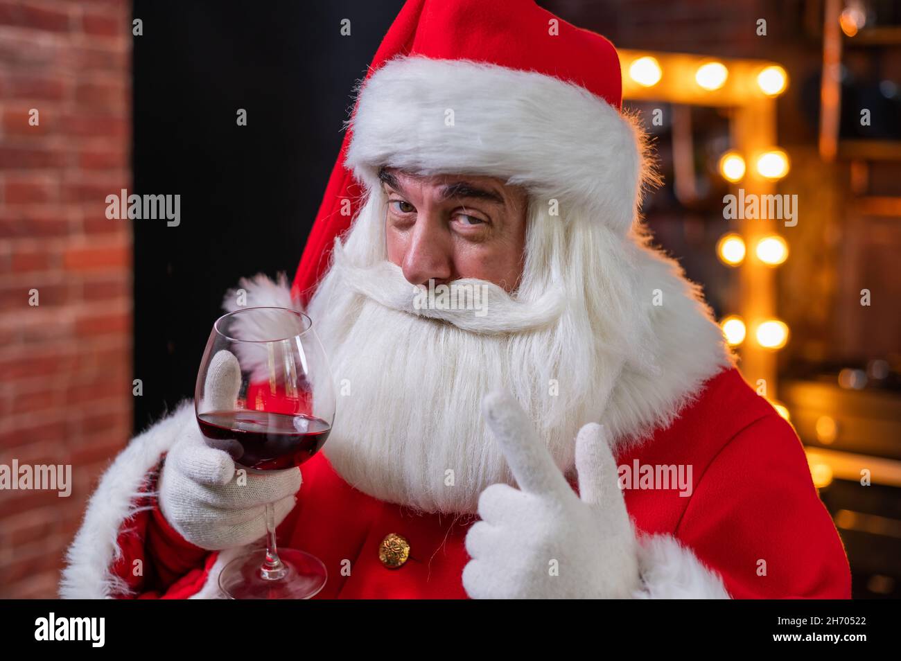 Santa claus with a glass of red wine wishes merry christmas and says ...