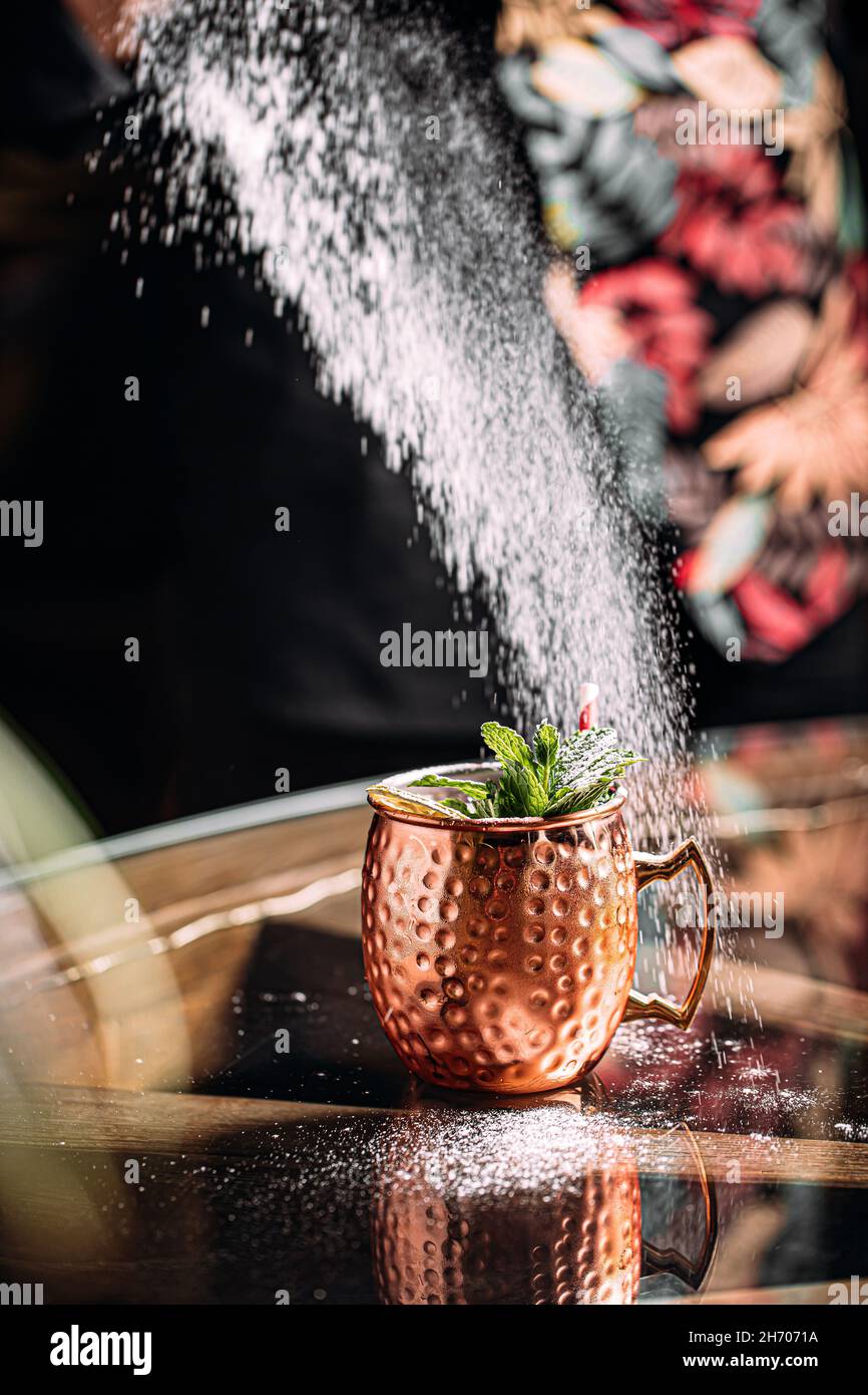 Bartender making cocktail in copper mug with sugar Stock Photo - Alamy