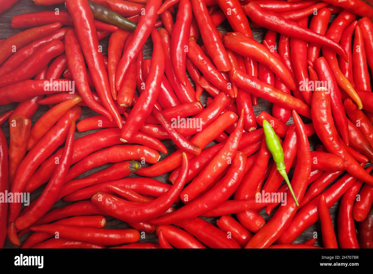 Green chili peppers on a background of red spicy pods Stock Photo - Alamy