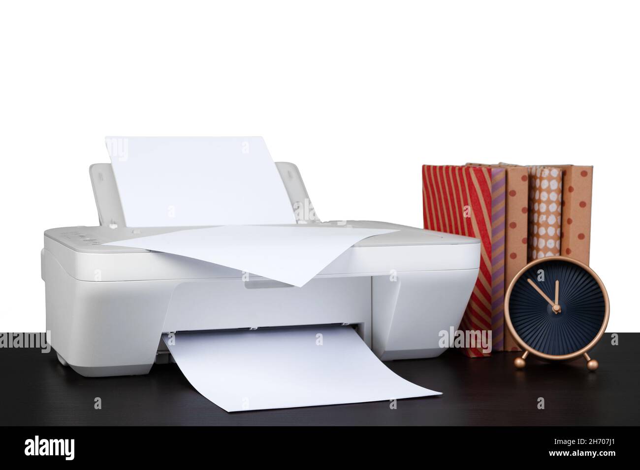 Printer and stack of books on black table against white background ...