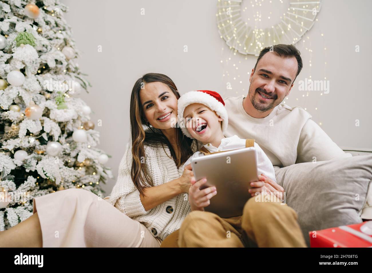 Happy family having fun on digital tablet in bed on Christmas Stock ...