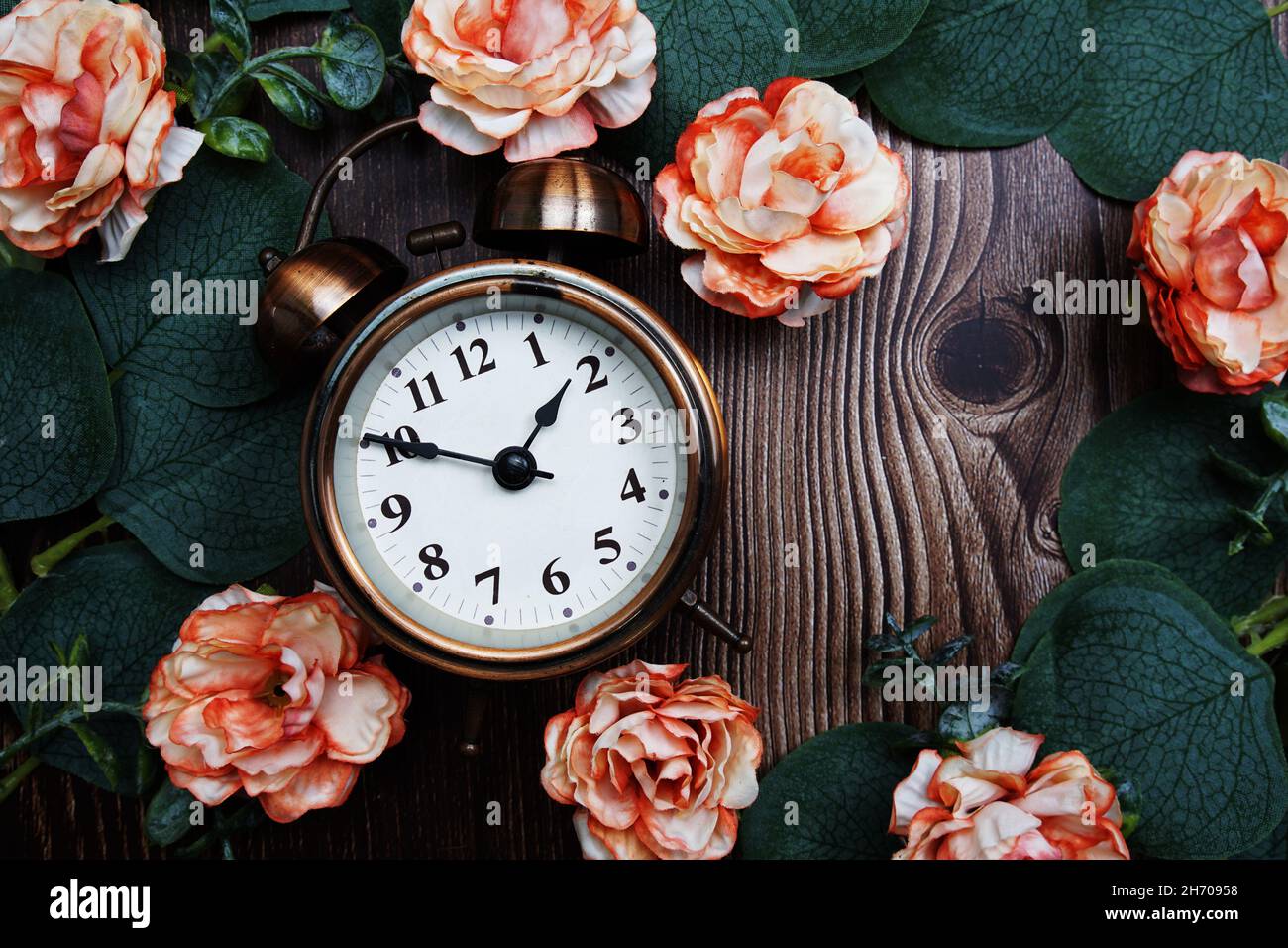 Alarm clock with eucalyptus leaves and flower decorate on wooden ...